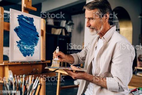 스튜디오에서 아티스트 페인트 브러시를 들고 팔레트에 색상을 혼합 이젤 앞에 앉아 집중 수염 남자 노인 남자에 대한 스톡 사진 및 기타 이미지 Istock