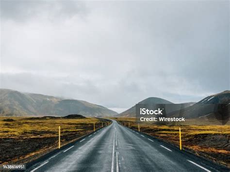 아이슬란드의 흐린 하늘 아래 녹지와 눈으로 덮인 언덕으로 둘러싸인 도로 0명에 대한 스톡 사진 및 기타 이미지 0명 강