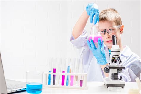 현미경을 가진 여학생은 시험관에서 화학 물질을 검사하고 실험을 실시합니다 흰색 배경에 초상화 실험실에서 코로나 바이러스의 연구를위한 개념 검사 보기에 대한 스톡 사진 및