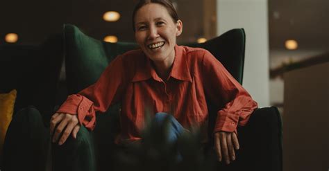 녹색 벨벳 안락의자에 앉아 웃는 여자 · 무료 스톡 사진