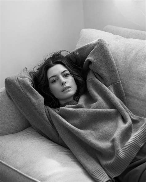 A Woman Laying On Top Of A Couch Under A Blanket