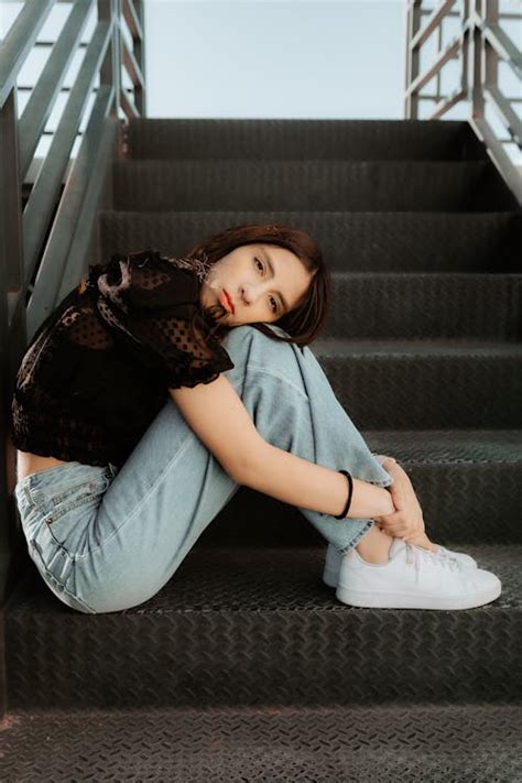 갈색 머리 거리 패션 검은 색 블라우스 계단에 앉아있다 고요한 금속 계단 도시 설정 도시 패션 도시 환경 도시의 삶 라이프스타일 레저 명상 적
