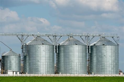 건조 청소 및 농산물 저장을 위한 농업 제조 공장의 은 사일로 밀가루 곡물 및 곡물 곡물의 대형 철 배럴 곡물 창고 엘리베이터 프리미엄 사진