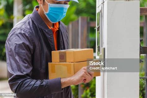 배달 남자는 위생 마스크와 파란색 모자를 착용 종과 고객의 집 앞에서 골판지 상자를 들고 배달에 대한 스톡 사진 및 기타 이미지 배달 상자 소포 Istock
