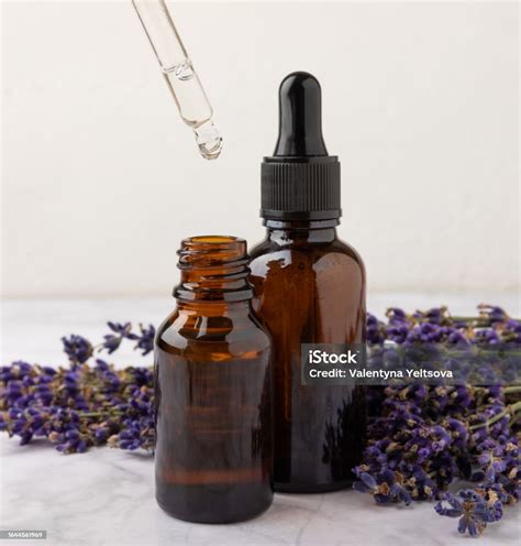 배경에 라벤더의 에센셜 오일입니다 스파 개념입니다 늦추다 향긋한 오일과 라벤더 꽃이 든 병 라벤더 향기가 나는 아로마 오일라벤더 에센셜 오일의 모형 복사 공간 건강관리와