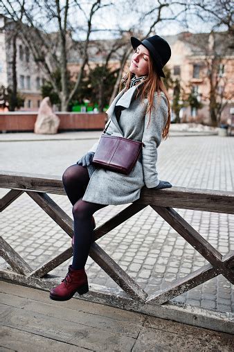 어깨에 가죽 핸드백과 회색 코트와 검은 모자에 젊은 모델 소녀는 도시의 거리에서 나무 기둥에 대 한 포즈 가방에 대한 스톡 사진 및 기타 이미지 Istock