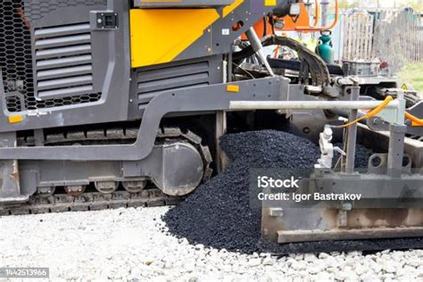 도 공사 중 아스팔트 포장 재료 기계를 운영 하 고 복구 작업자 작동 합니다 포장 재료 피니셔 아스팔트 피니셔 또는 포장 기계는 아스팔트의 레이어를 배치 합니다 싫지만 0