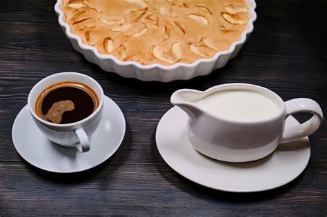 어두운 나무 배경에 잘 익은 사과의 홈 베이킹 요리와 크림에 과일 케이크 큰 사과 파이와 커피와 크리머 한 잔 0명에 대한 스톡