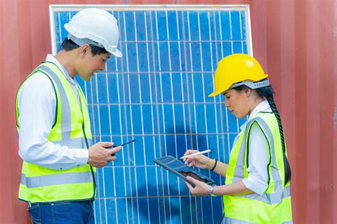 신재생 에너지 작업의 혁신적인 보다 효율적인 태양전지 패널 배터리 개념을 충족하는 비즈니스 엔지니어 야외 테스트 태양광 전지 모듈을 위해 모인 전문가 2명에 대한 스톡 사진