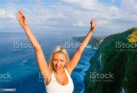 젊은 행복하고 아름다운 금발의 여자는 관광 여행 목적지 개념에서 낙원 섬에서 여름 휴가 휴양지 를 즐기는 열대 해변 절벽 풍경에서 쾌활하게 미소 30 39세에 대한 스톡