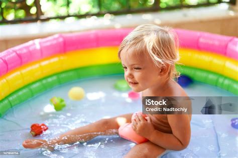 어린 소녀는 장난감과 함께 발코니의 수영장에 앉아 있다 개수대에 대한 스톡 사진 및 기타 이미지 개수대 건축물 고여 있는 물 Istock