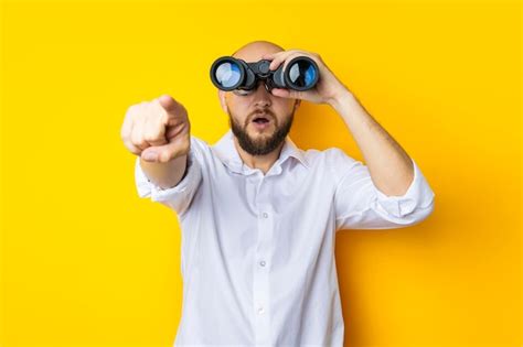 Jeune Homme Surpris Regardant à Travers Des Jumelles Pointant Son Doigt