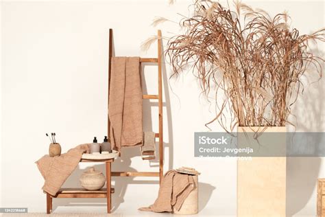 나무 벤치에 흙 색조의 천연 와플 린넨 수건과 대나무 칫솔 등나무 바구니 및 비누 디스펜서가있는 수건 사다리 데일리 바디 케어 스파 및 웰빙 제로 폐기물 욕실 개념 개념에