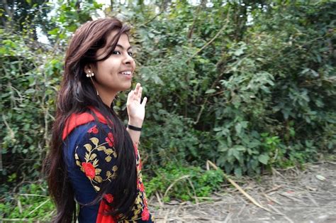 웃는 십대 소녀 는 식물 들 에 맞서 서서 눈을 돌리고 있다 프리미엄 사진