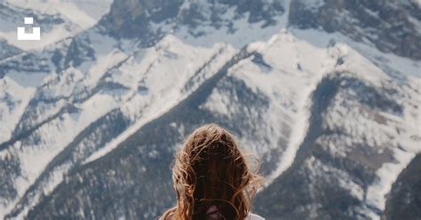 낮에 눈 덮인 산을 바라보는 주황색과 흰색 셔츠를 입은 여자 사진 Unsplash의 무료 캐나다 이미지