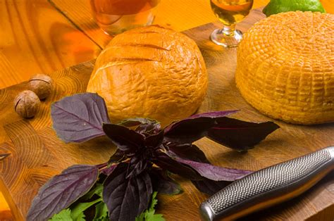 국가 Adyghe 치즈 칼 바 질 파 슬 리 석 회 참기름 칠리 페 퍼 마 카 다 미아 너트와 나무 테이블에 디 켄 터와 절삭 보드에 만든 클로즈업 갈색에 대한 스톡 사진