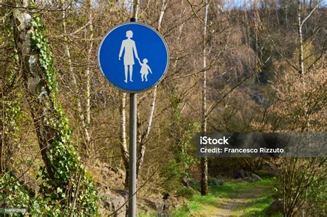 보행자를 위한 숲으로 들어가는 산책로에 대한 정보로 엄마와 아이와 함께 서명하십시오 도로 표지판은 기둥에 파란색으로 표시되어 있습니다 자동차 오토바이 및 자전거는 이 경로를