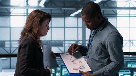 Data Center Team Examines Paperwork Files In Server Room Reviewing System Stock Footage Video