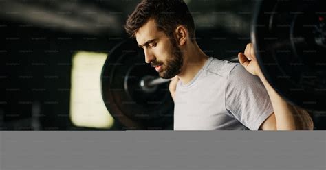 체육관에서 근력 운동을 하는 동안 바벨로 운동하는 남자 운동선수 사진 Unsplash의 사진술 이미지