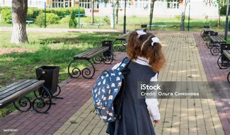 배낭을 메고 학교 운동장에서 교복을 입은 학생이 프레임으로 돌아갑니다 9월 1일 학교로 돌아갑니다 행복한 학생 초등 교육 초등 수업 삶으로 지식으로 가는 길 6 7 살에