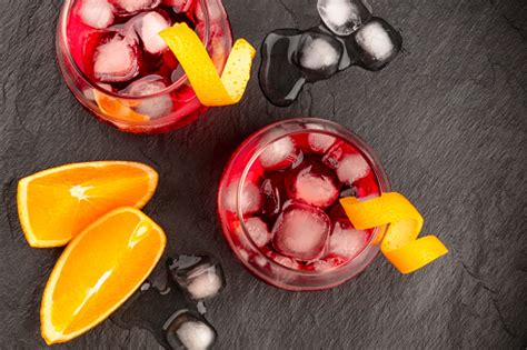 캄 파리와 트위스트 오렌지 묘미 안주 얼음 조각 및 과일 조각 텍스트에 대 한 장소를 가진 검은 배경에 위에서 총 두 활기찬 Negroni 칵테일 칵테일에 대한 스톡 사진