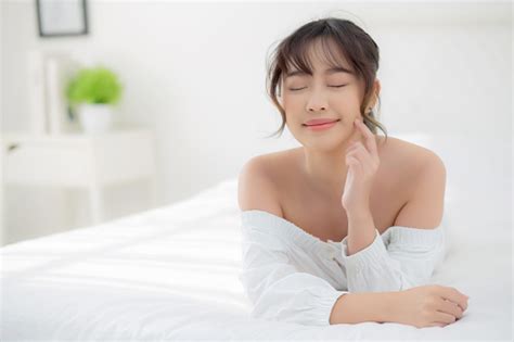 아침에 일출과 함께 일어나면서 누워 있는 아름다운 초상화 젊은 아시아 여성 침실 라이프 스타일 및 휴식 개념의 침대에서 행복하고 쾌활한 휴식을 취하는 아름다운 초상화 가정