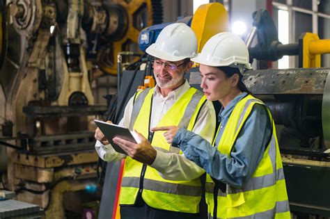 프로젝트 관리자와 엔지니어는 공작물을 검사하고 공장의 제품 및 안전에 대한 표준 및 안전성을 확인합니다 기술자와 여성 노동자가 공장에서 회의에 대해 이야기하고 있다 2명에