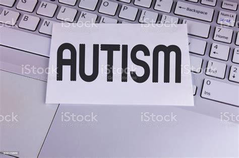 개념적 손을 자폐증을 보여주는 작성입니다 비즈니스 사진 자폐증 인식 화이트 스티커 메모 용지에 작성 된 전세계 사회 위원회에 의해 진행을 보여주는 노트북에 배치 감정에 대한
