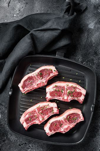 생 양고기 허리 갈비는 로즈마리와 백리향을 곁들인 그릴 프라이팬에 스테이크를 찹니다 검은 배경 위쪽 보기 0명에 대한 스톡 사진 및 기타 이미지 Istock