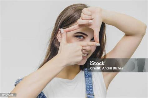 프레임 손가락 기호를 보여주는 여자 젊은 여성이 손으로 자신을 프레이밍 흰색 배경에 고립입니다 갈색 머리에 대한 스톡 사진 및