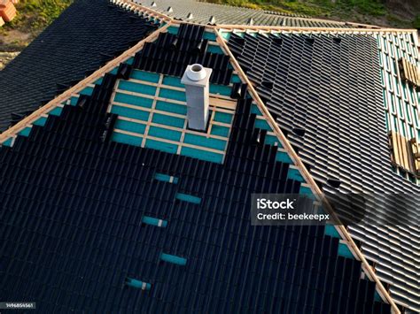 여러 지붕이 진행 중인 건설 현장 증기 투과성 호일이있는 지붕 지붕 타일은 지붕에 배치됩니다 콘크리트 굴뚝이 통과합니다 승인 품질 관리 위에서 본 모습 개발에 대한 스톡
