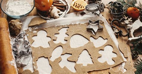 크리스마스 쿠키와 나무 롤링 핀 아니스 생강 계피 솔방울 전나무 가지 소박한 테이블에 밀가루를위한 다양한 모양의 금속 커터가있는 진저 브레드 반죽 사진