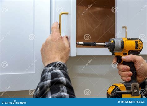 The Installing A Furniture Handle Process Of Assembling Cabinet Stock