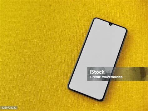 검은 색 모바일 스마트 폰 모형은 노란색 직물 배경에 격리 된 빈 화면으로 표면에 놓여 있습니다 0명에 대한 스톡 사진 및 기타 이미지 Istock
