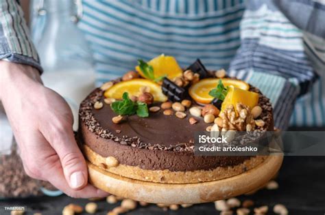 땅콩과 견과류와 초콜릿 케이크 오렌지와 민트 잎으로 장식 된 손 채식주의자를 위한 건강 한 생 디저트 과일에 대한 스톡 사진 및 기타 이미지 Istock
