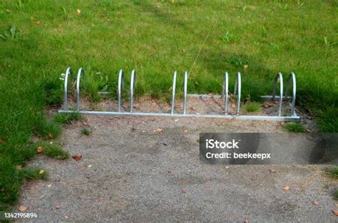 잔디밭에 있는 직사각형 모양의 회색 판금 튜브의 자전거 바퀴 랙 도시의 화강암 큐브 포장 자갈 공원 경로 정원에 대한 스톡 사진 및 기타 이미지 Istock