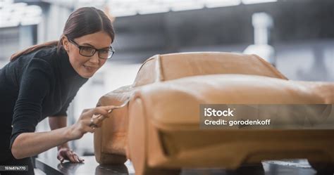 여성 자동차 디자이너가 새로운 생산 차량의 3d 점토 모델을 트리밍하는 모습을 클로즈업합니다 주걱을 사용하여 프로토타입 지속 가능한 차량의 표면을 신중하게 조각하는 전문