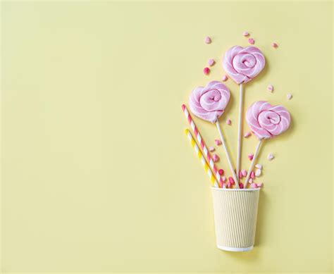 Розовые леденцы в форме сердец на бумажном стаканчике с цветным сахаром ...