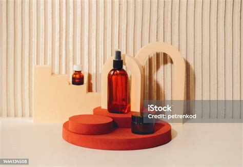 질감 베이지색 배경에 대해 둥근 연단에 서 있는 유리병에 담긴 화장품 스킨케어 제품이 있는 추상적인 구성 텍스트를 위한 복사