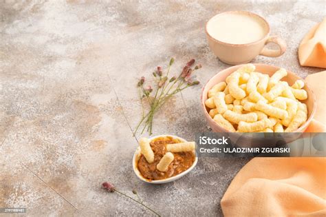 콘플레이크는 회색 콘크리트에 세라믹 그릇에 캐러멜과 함께 붙어 있으며 측면도 복사 공간 0명에 대한 스톡 사진 및 기타 이미지 Istock