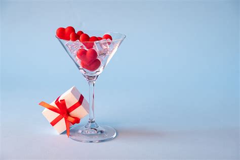 빨간 하트 모양의 설탕 사탕과 얼음과 선물 상자 파란색 배경 유리 사랑을 위한 시간 발렌타인 데이 기념일 또는 결혼 축하 개념입니다 공간을 복사합니다 마티니에 대한 스톡