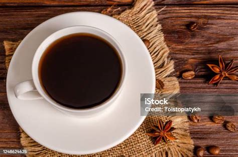 흰색 컵에 안스 스타와 시나몬 스틱이 있는 검은 색 향기로운 커피 한 잔이 나무 배경에 붙어 있습니다 0명에 대한 스톡 사진 및 기타 이미지 Istock