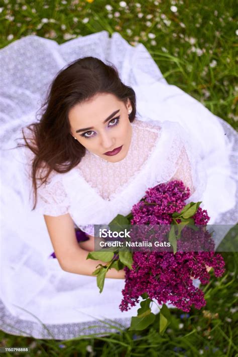 봄에 사과 과수원에서 라일락의 꽃다발과 함께 젊은 아름 다운 소녀 모델의 완벽 한 그림에 흰색 레이스 드레스 사진 세션을 엽니다 갈색 머리에 대한 스톡 사진 및 기타 이미지