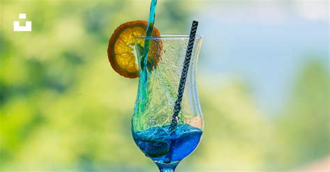 얇게 썬 오렌지 과일을 곁들인 투명한 와인 잔에 담긴 파란색 액체 사진 Unsplash의 무료 오르쇼바 이미지