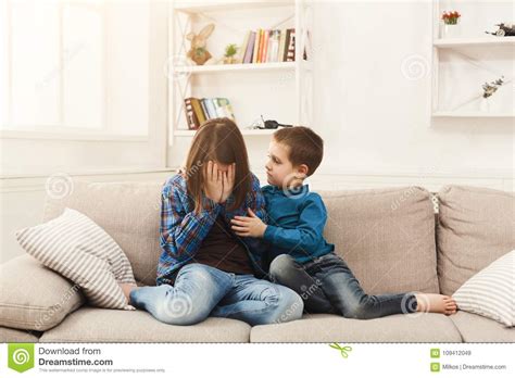 Pojke Som Hemma Kramar Hans Skriande Syster Fotografering För