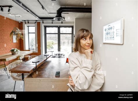 Woman Controlling Home Devices With Digital Smart Panel Mounted On The Wall Stock Photo Alamy