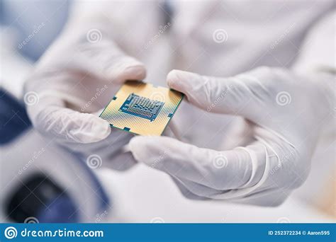 African American Woman Wearing Scientist Uniform Holding Cpu Microchip At Laboratory Stock Photo