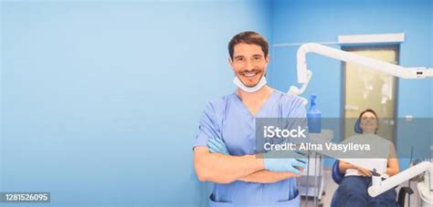 젊은 미소 잘 생긴 남성 의사 에 의료 유니폼 치과 사무실에서 장비와 일회용 의료 얼굴 마스크와 치과 의자에 행복 한 환자 스토마토로지 개념 복사 공간 치과 의사에 대한