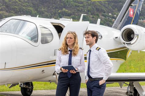 개인 제트기 외부의 조종사는 디지털 태블릿에서 비행 경로와 체크리스트를 준비합니다 20 24세에 대한 스톡 사진 및 기타 이미지 20 24세 25 29세 2명