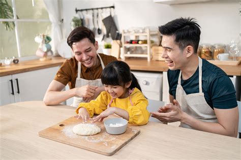 아시아 매력적인 Lgbtq 게이 가족 가르쳐 소녀 아이 만드는 효 모 반죽 잘 생긴 남성 부부는 돌보고 부엌에서 작은 사랑스러운 아이 빵집과 함께 시간을 보내고 집에서 육아